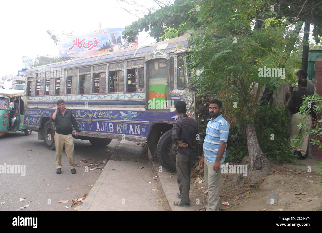 KARACHI, PAKISTAN, AUG 29: People look damaged passenger bus that was ...