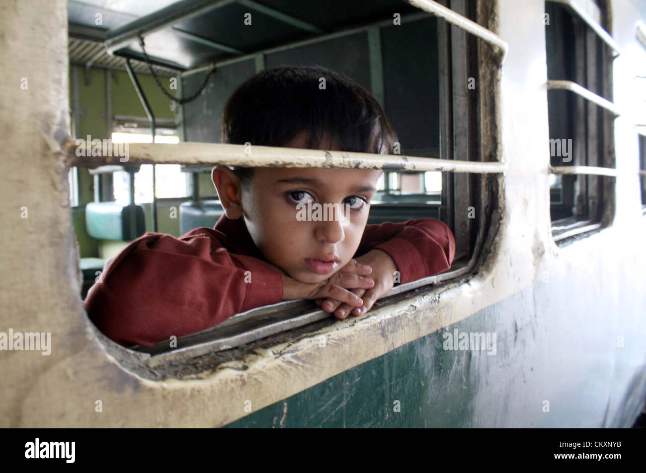 A child sits worried in train at platform as trains are late from their ...
