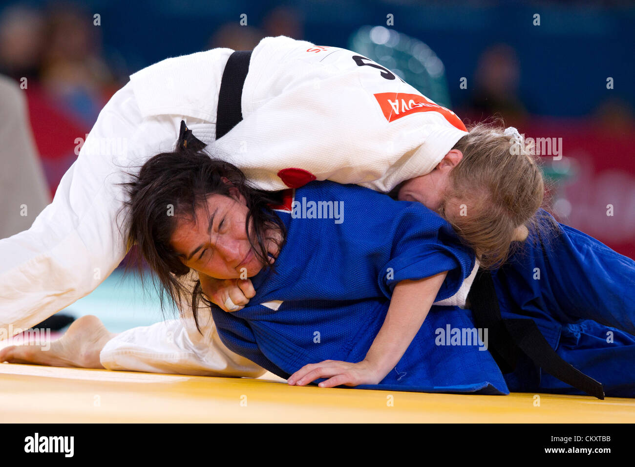 Russia's Victoria Potapova (top) ties up Xiaoli Huang (blue) of China ...
