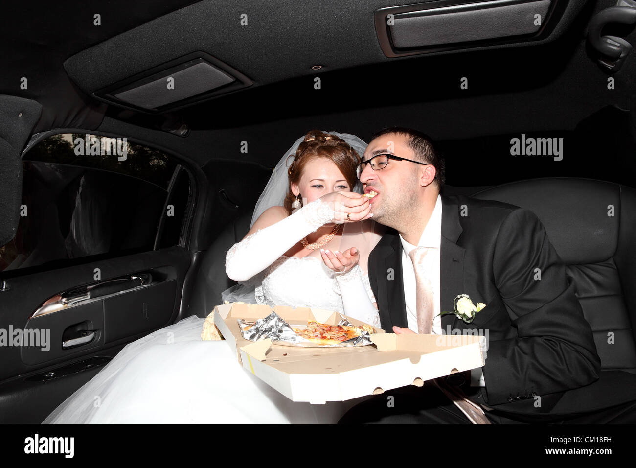 bride and groom eating pizza in the limousine Stock Photo - Alamy
