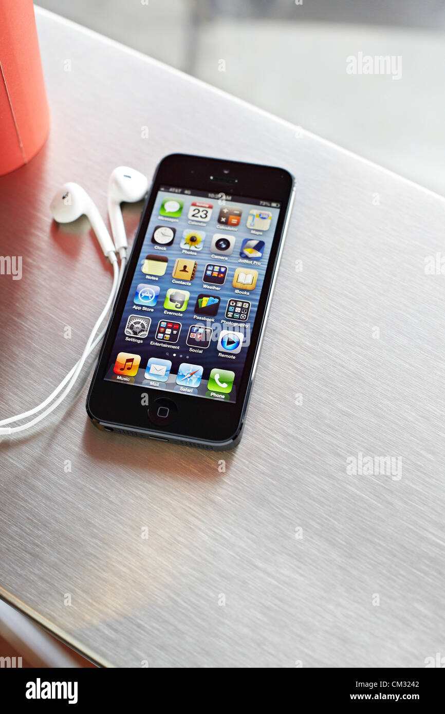 Inside a coffee shop, a newly released, black, Apple iPhone 5 sits face ...