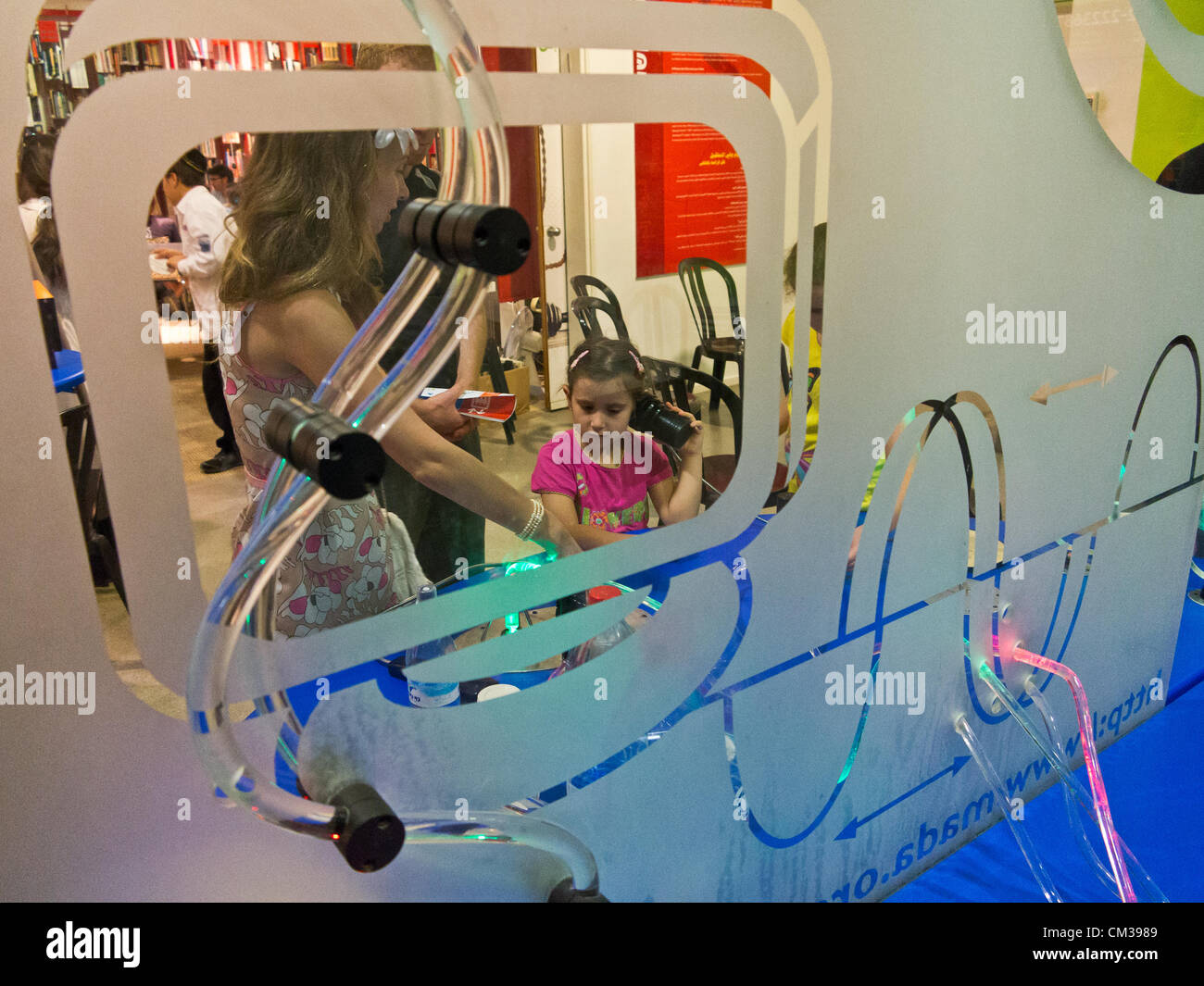 A young girl experiments with sound waves traveling through pipes at ...