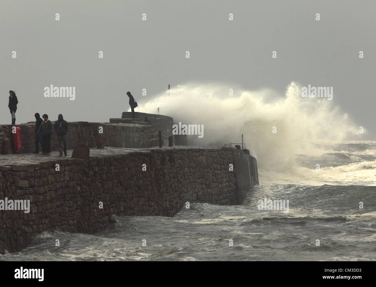 Rough sea waves crash around visitors during a storm at St Andrews ...