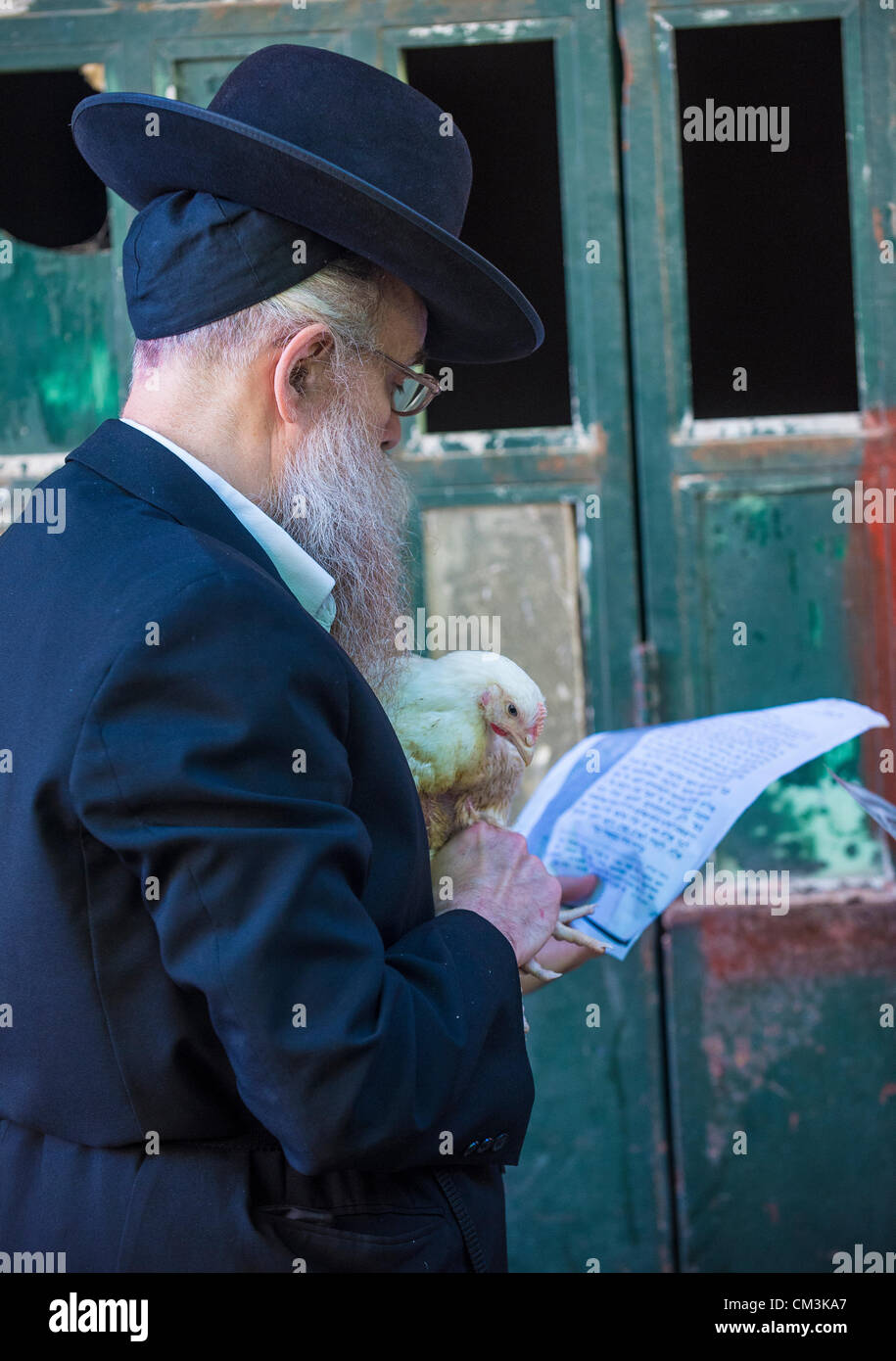 An ultra Orthodox Jewish man prays with a chicken during the Kaparot ...