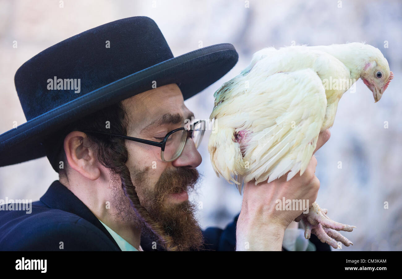 An ultra Orthodox Jewish man prays with a chicken during the Kaparot ...