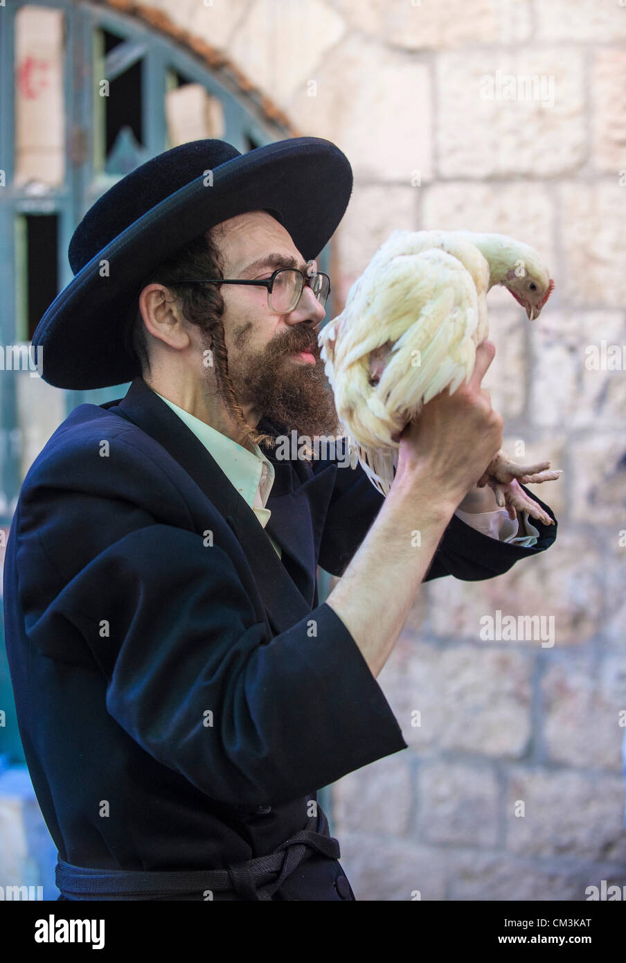 An ultra Orthodox Jewish man prays with a chicken during the Kaparot ...