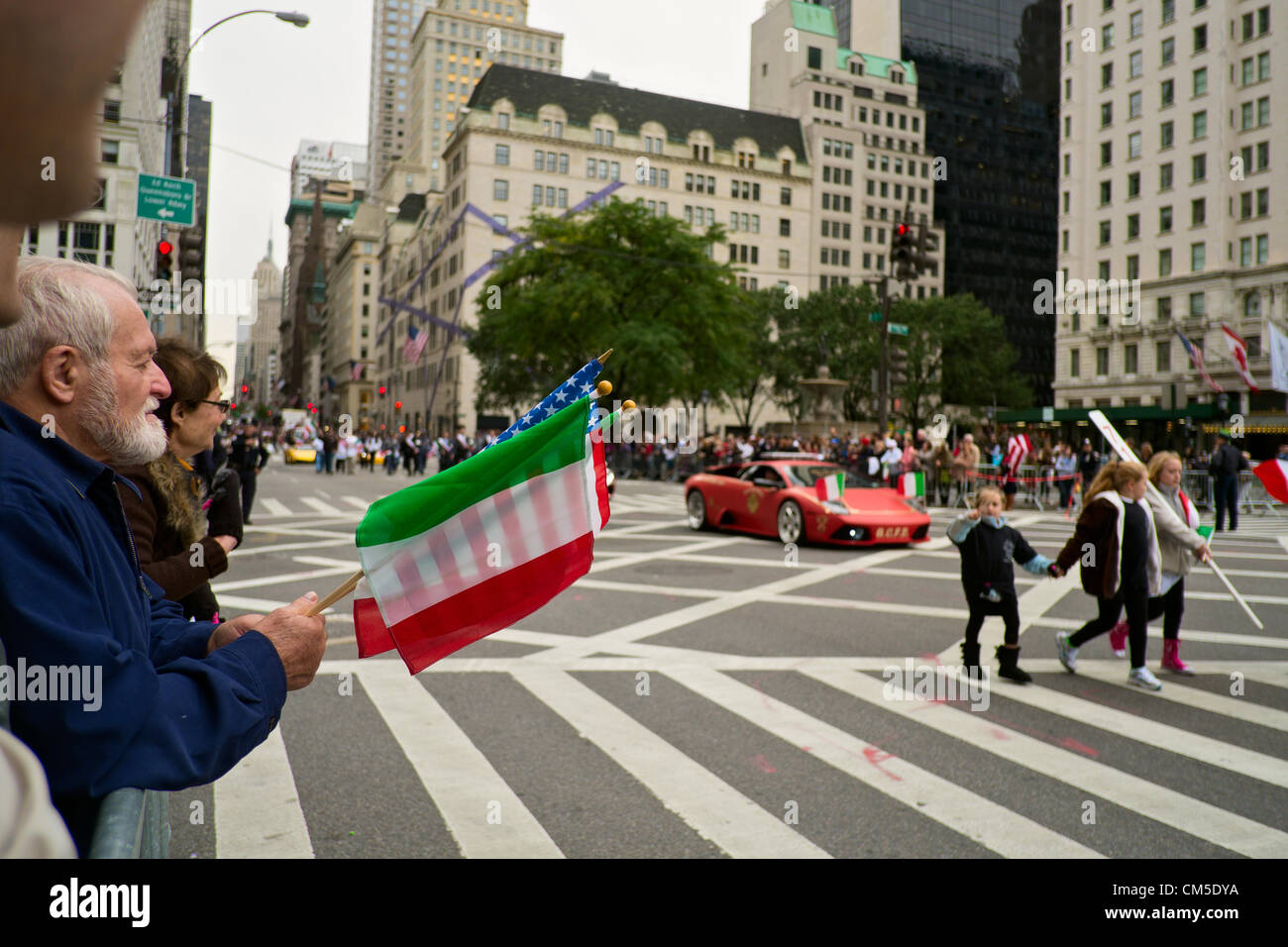 New York, NY, October 8, 2012. Man in crowd holds US and Italian flags ...