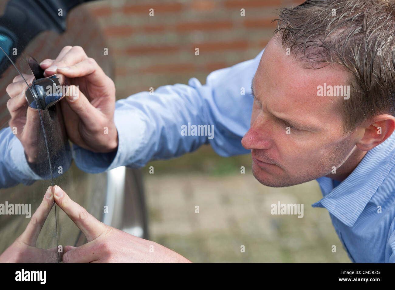 Mid adult man checking his car for scratches and dents. Horizontal shot ...
