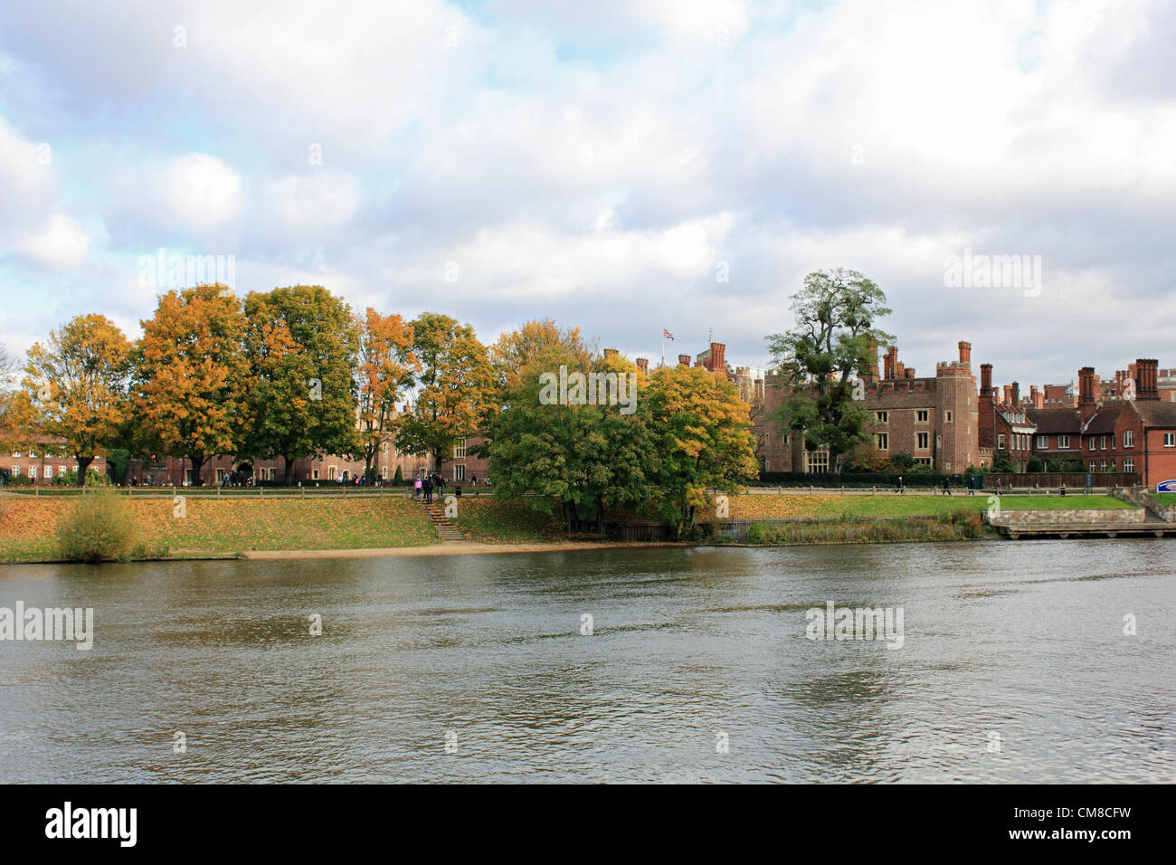 Colourful autumn trees line the River Thames path beside Hampton Court ...