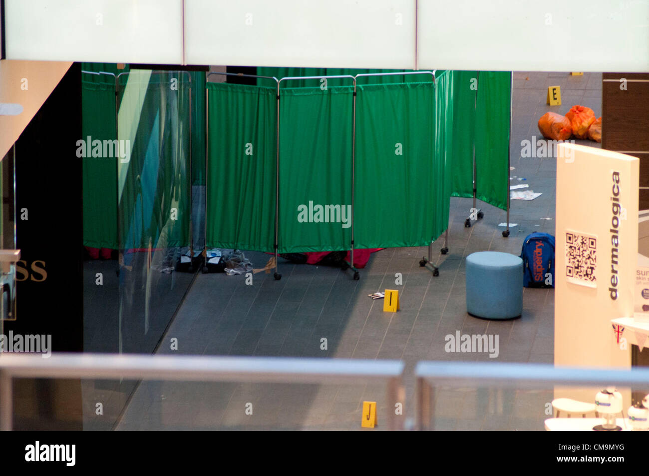 London, UK. 29/06/12. The body of a stabbing victim lies behind a green ...