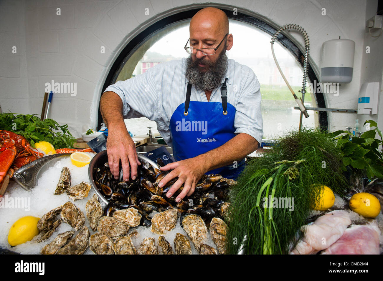 A fishmonger arranging his display of shellfish at the Cardigan Bay ...