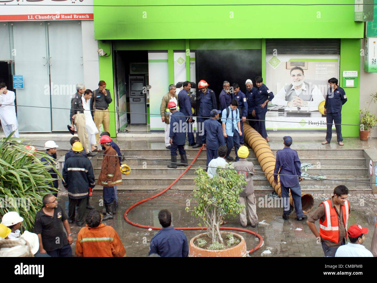 Firefighters extinguish fire on burning building of a local bank after ...