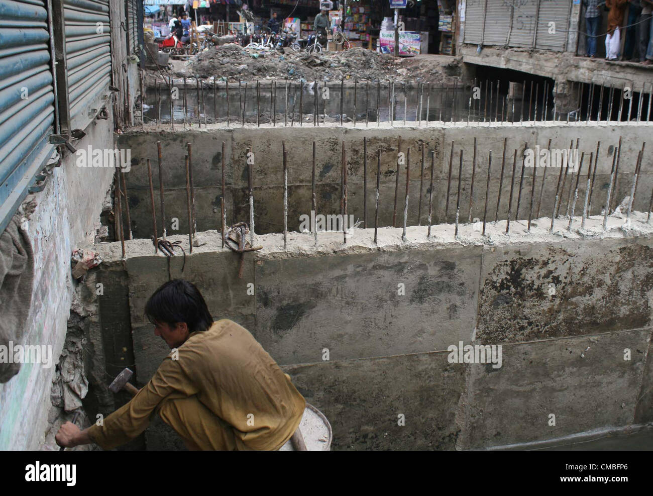 A Labor busy in construction work of sewerage water drain at Urdu Bazar ...