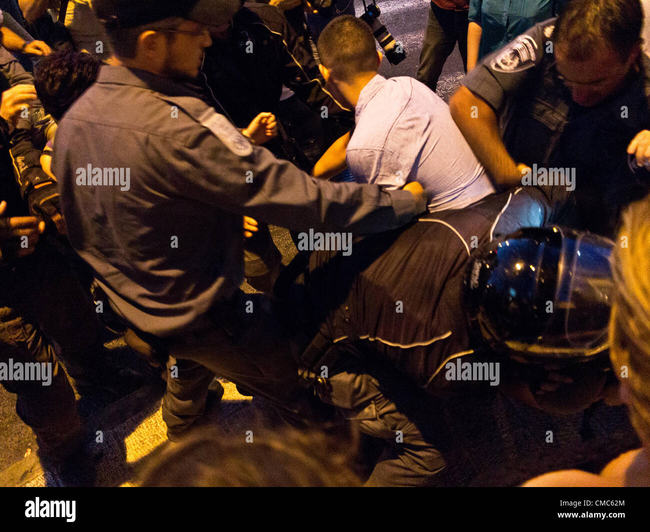 Policemen use force to pry activists from the hold of their friends as ...