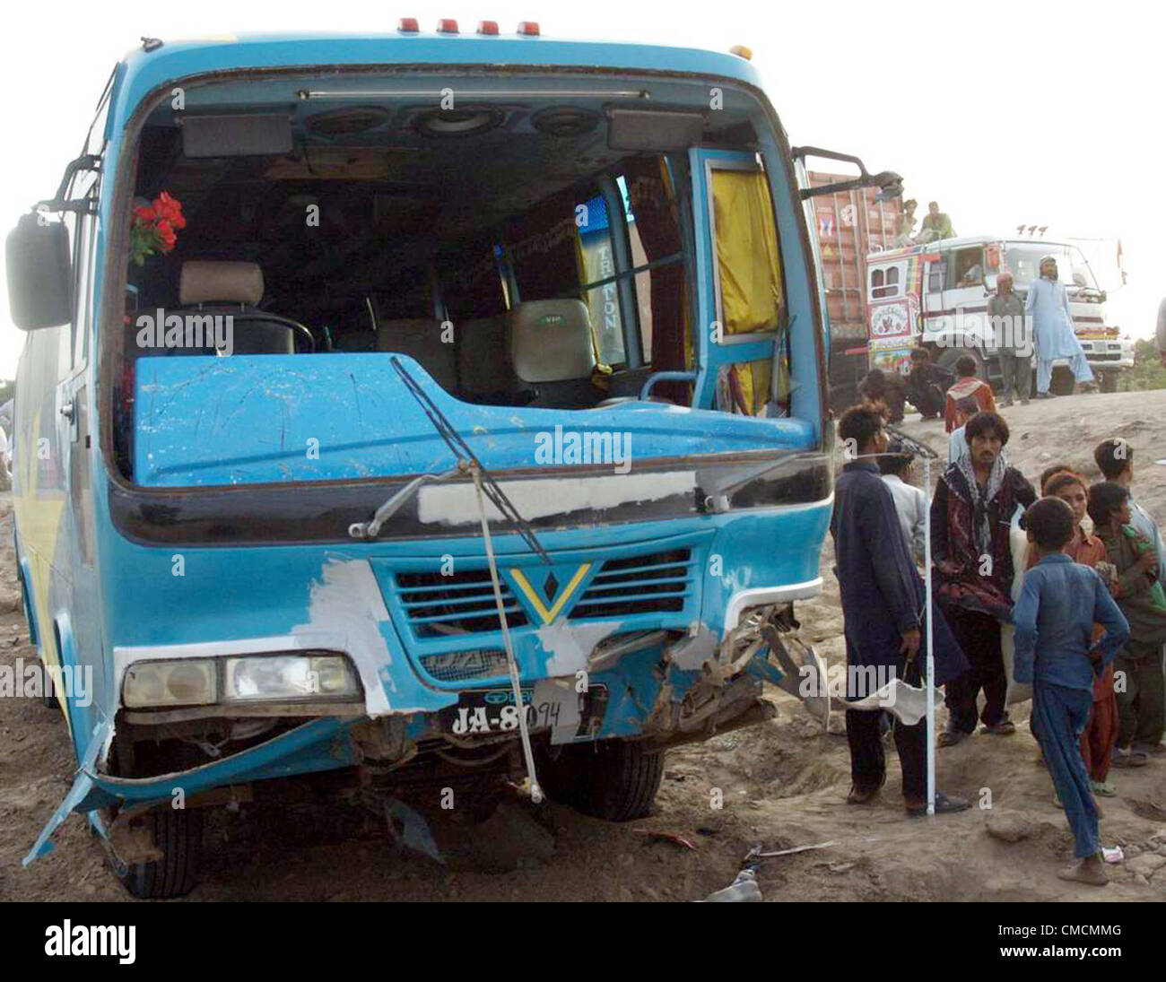 People gather near damaged passenger bus that was destroyed in traffic ...