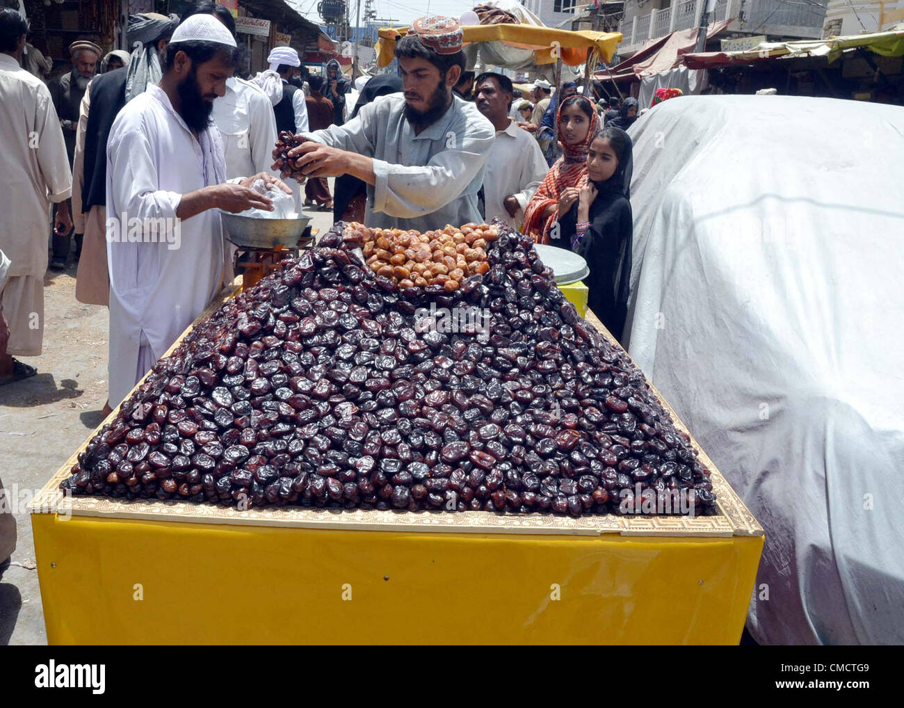 QUETTA, PAKISTAN, JUL 20: A man buys dates at a push-cart, ahead the ...