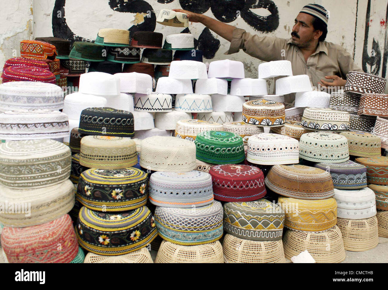 A man sells prayer caps at roadside stall at M.A Jinnah road to earn ...