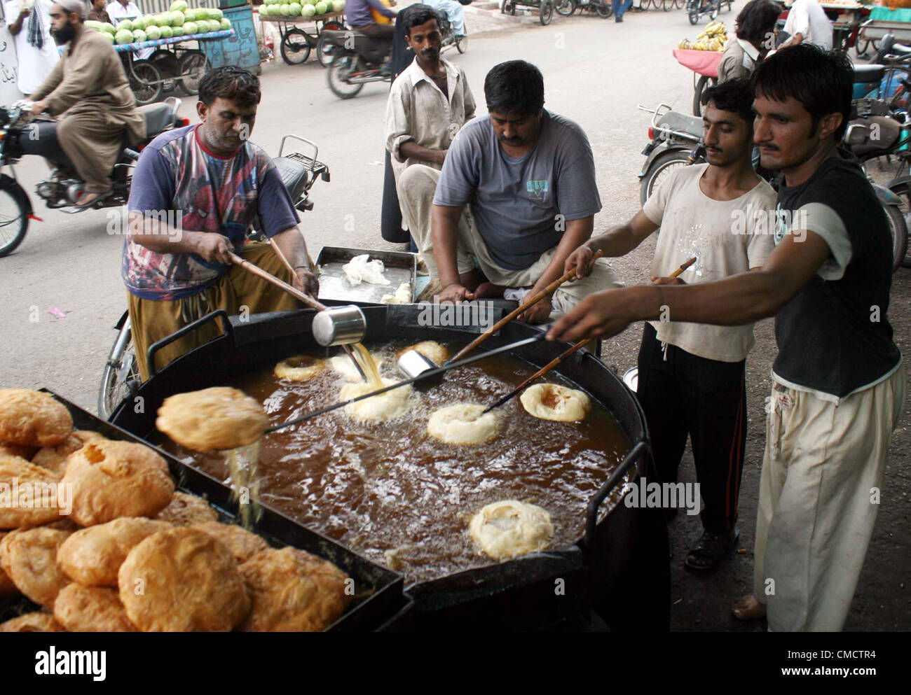 Labours busy to prepare "Khajla" (a traditional dish) at their shop to ...