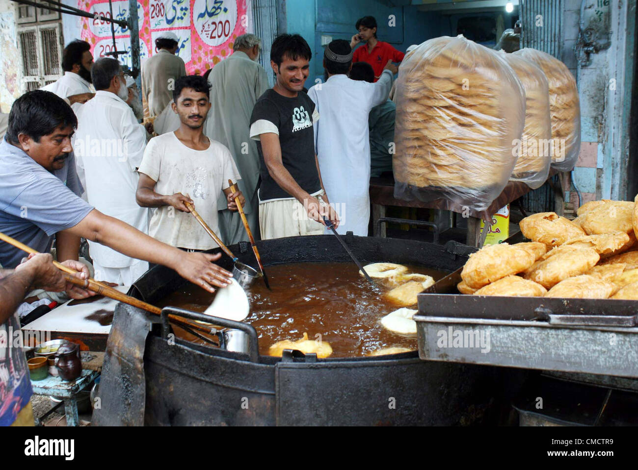 Labours busy to prepare "Khajla" (a traditional dish) at their shop to ...