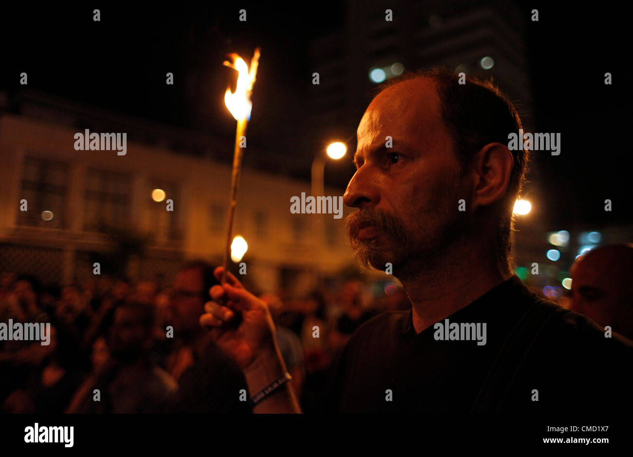 An Israeli demonstrator holds a lit torch during a demonstration in ...