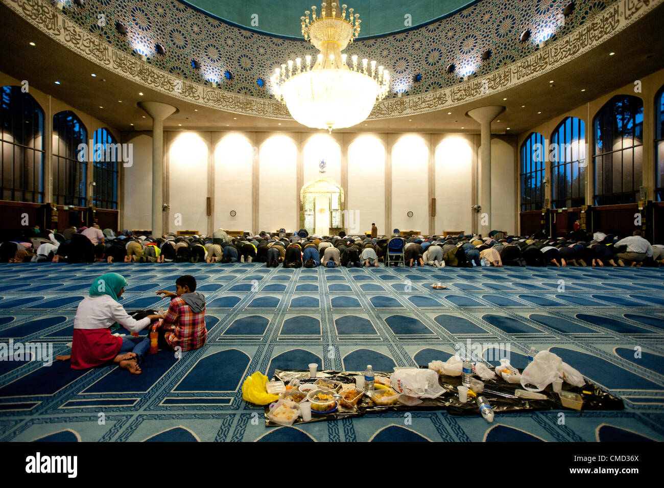 London, UK - 21 July 2012: Two children sit near a banquet while Muslim ...