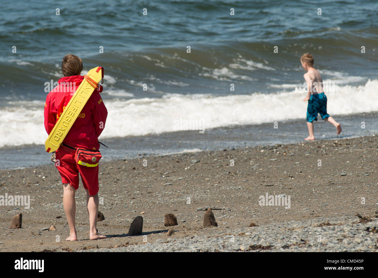A lone lifeguard watches over a boy playing in the waves. Temperatures ...