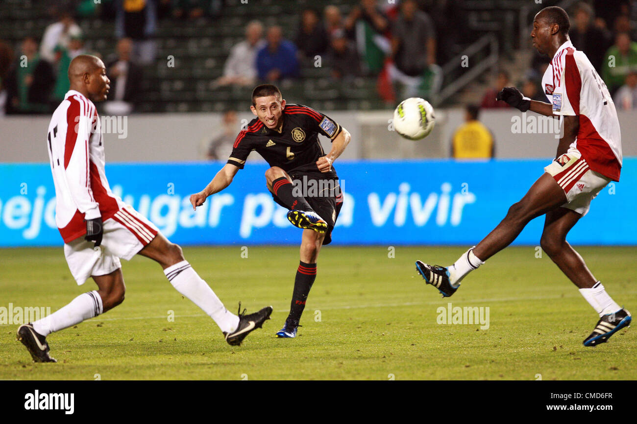 Mexico's Hector Herrera, center, kicks the ball against Trinidad ...