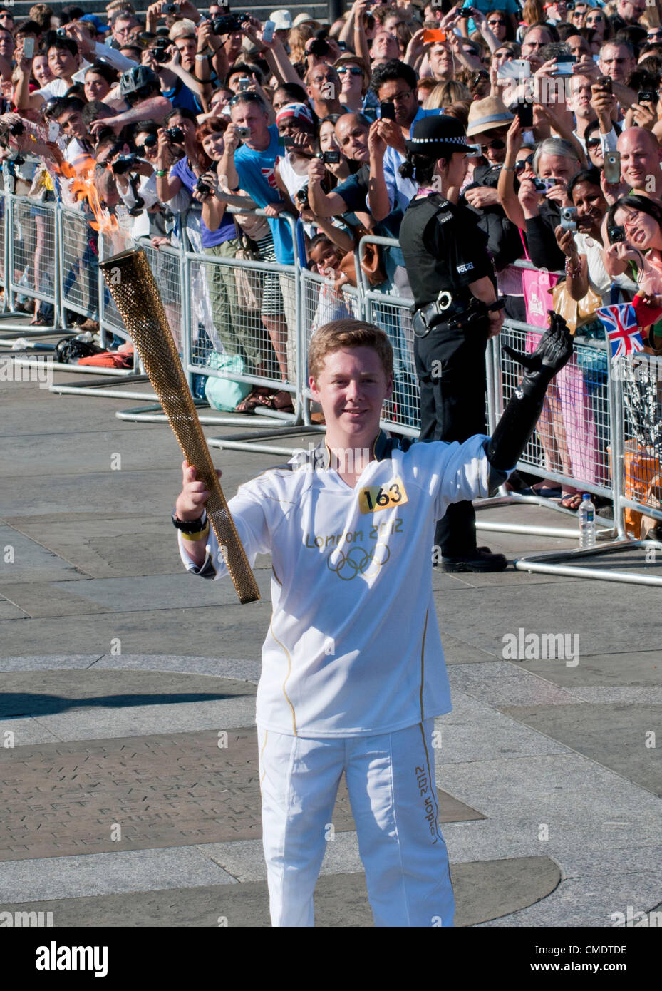 London, UK. 26/07/12. 15-year-old Patrick Kane carries the Olympic ...