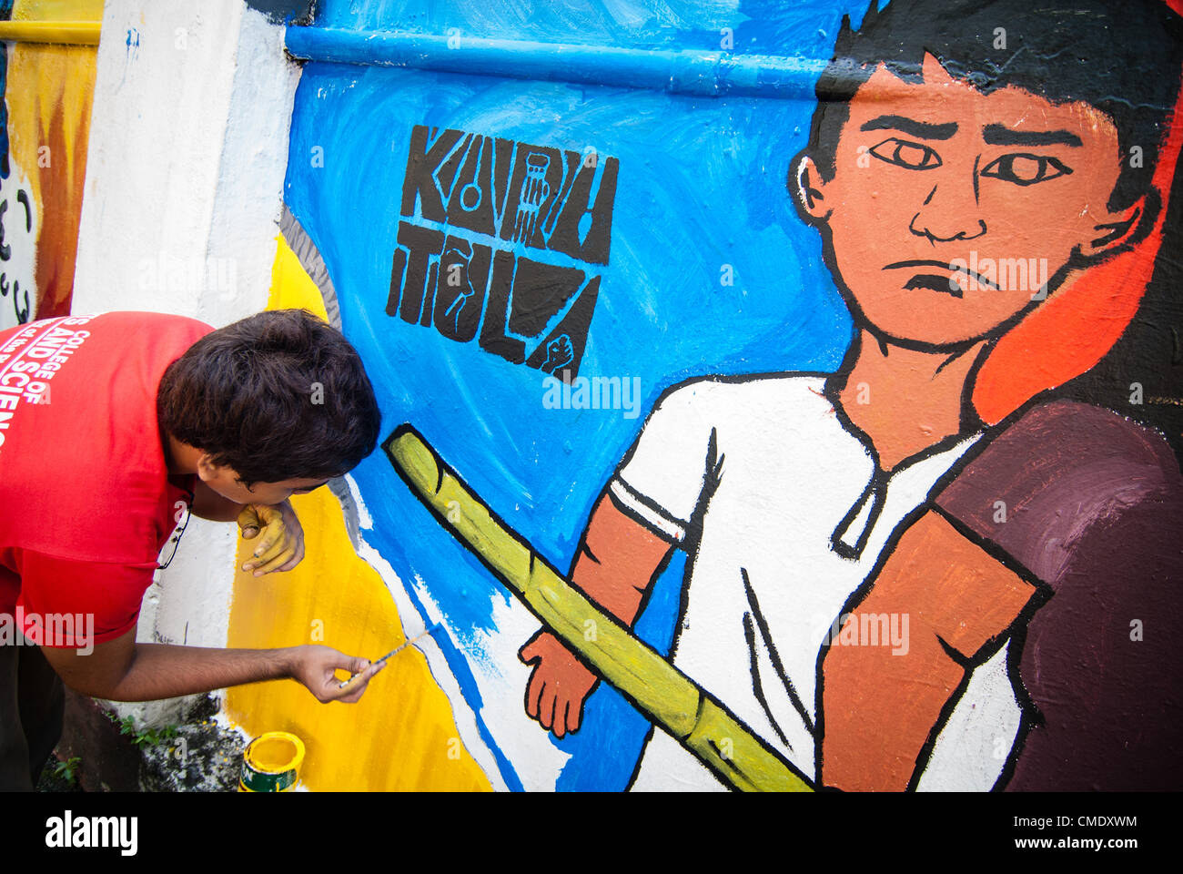A Filipino student applies details to a mural depicting the Philippine ...