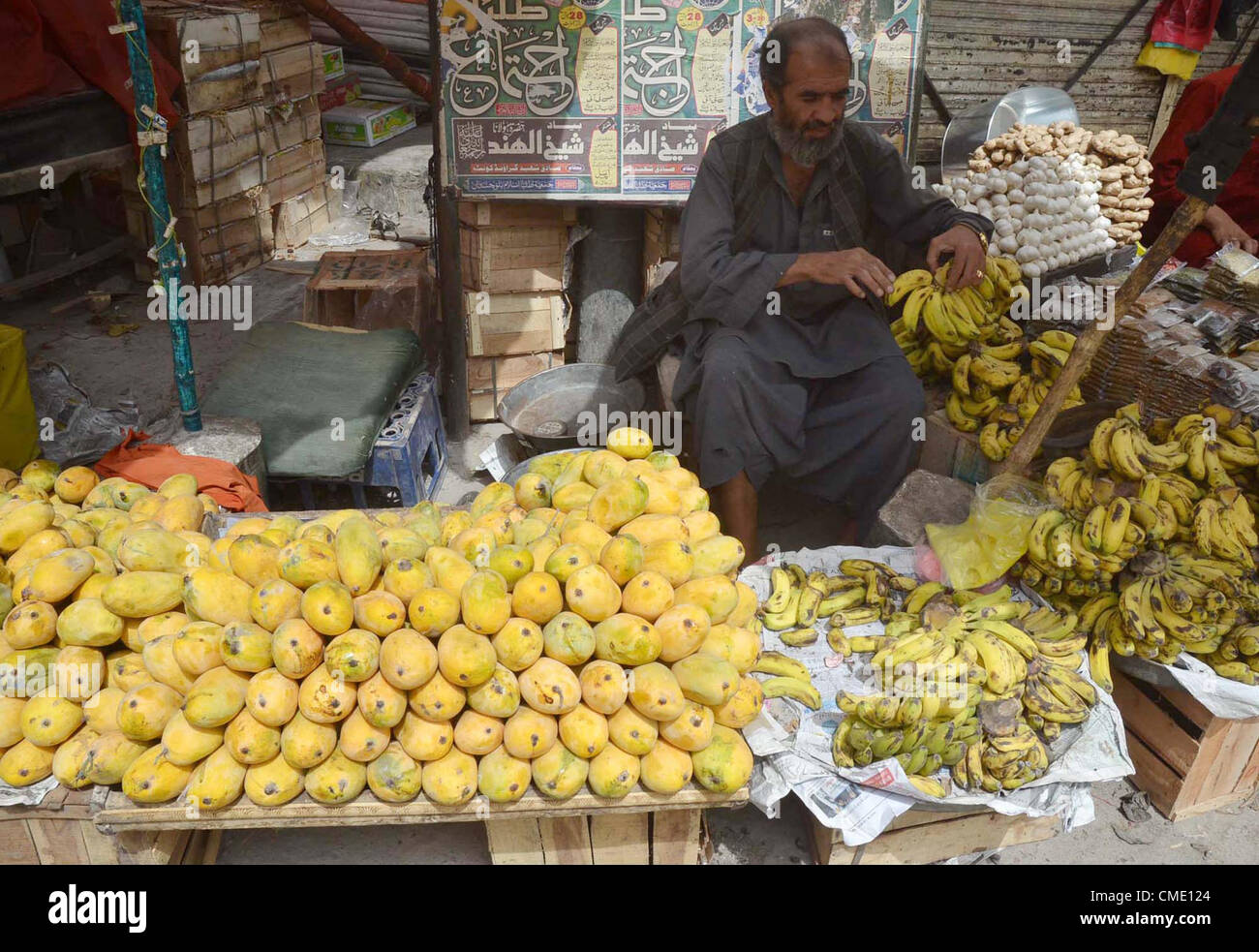 QUETTA, PAKISTAN, JUL 27: A man sells fruits at a roadside stall to ...