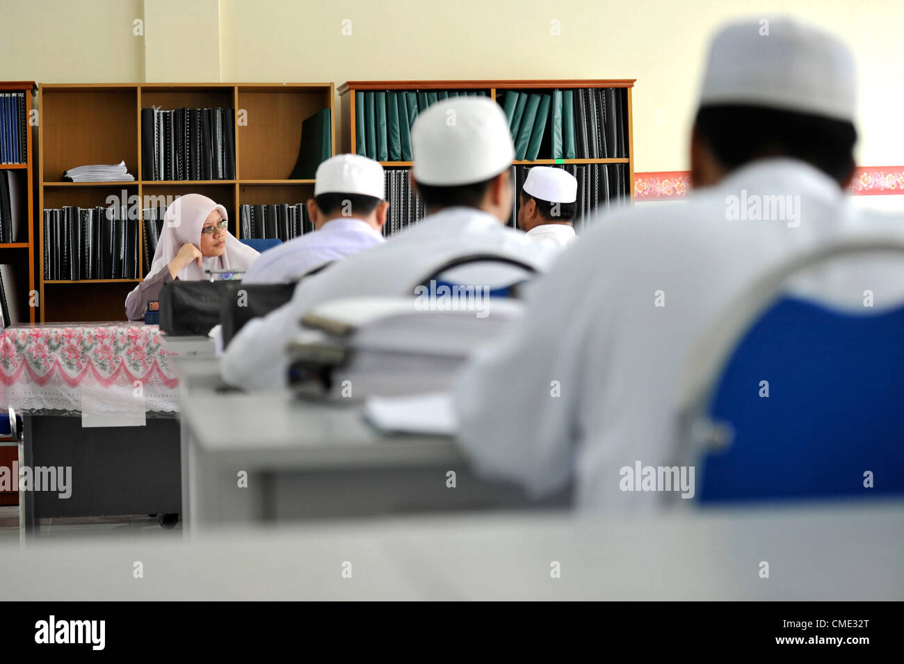 A lecture listens to her class as students recite from the Quran in ...