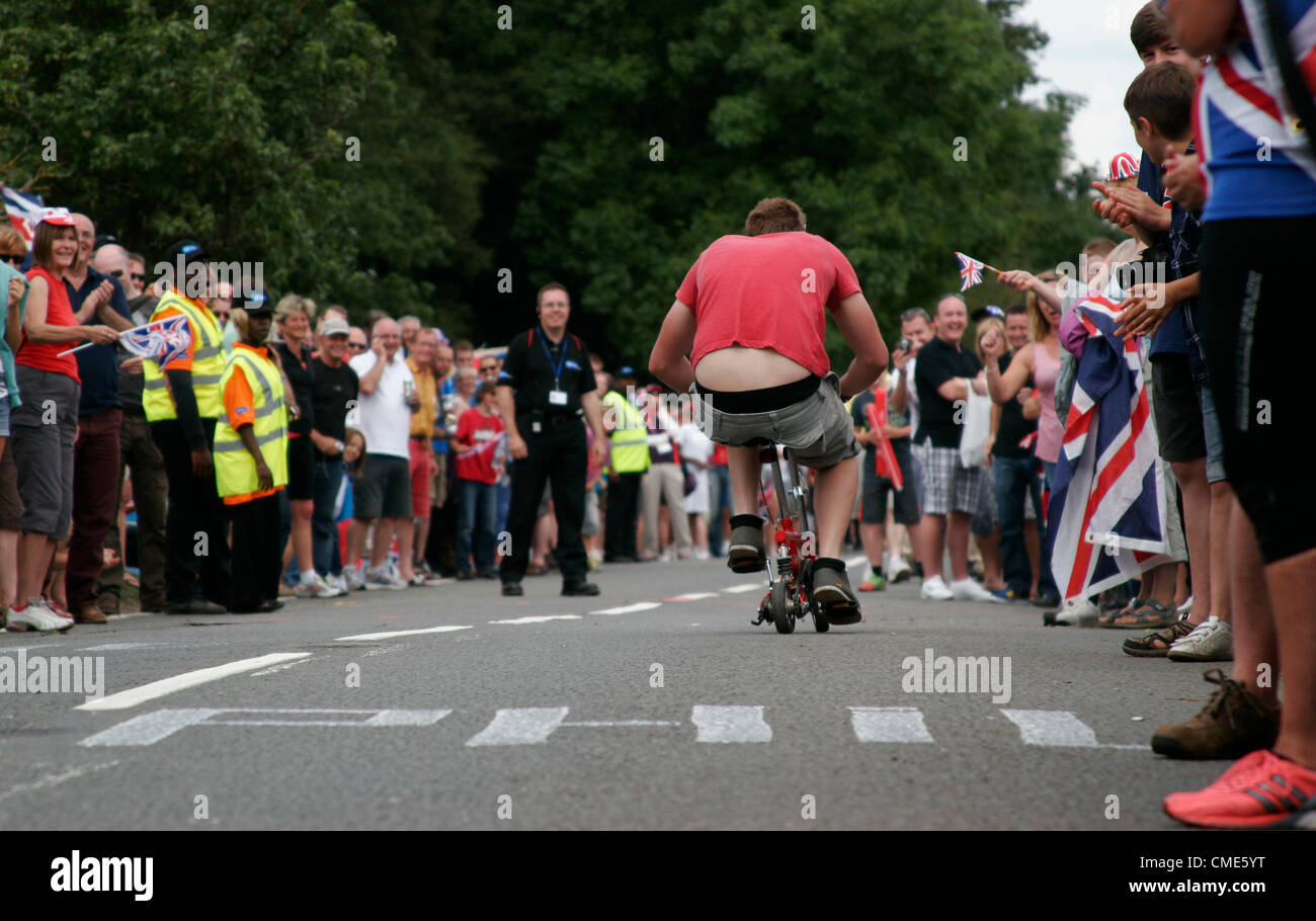 A spectator entertains the crowd by riding a mini bike on the route ...