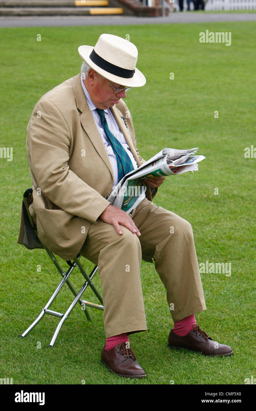01.08.12 CHICHESTER, ENGLAND Racegoers reading the Racing Post during ...