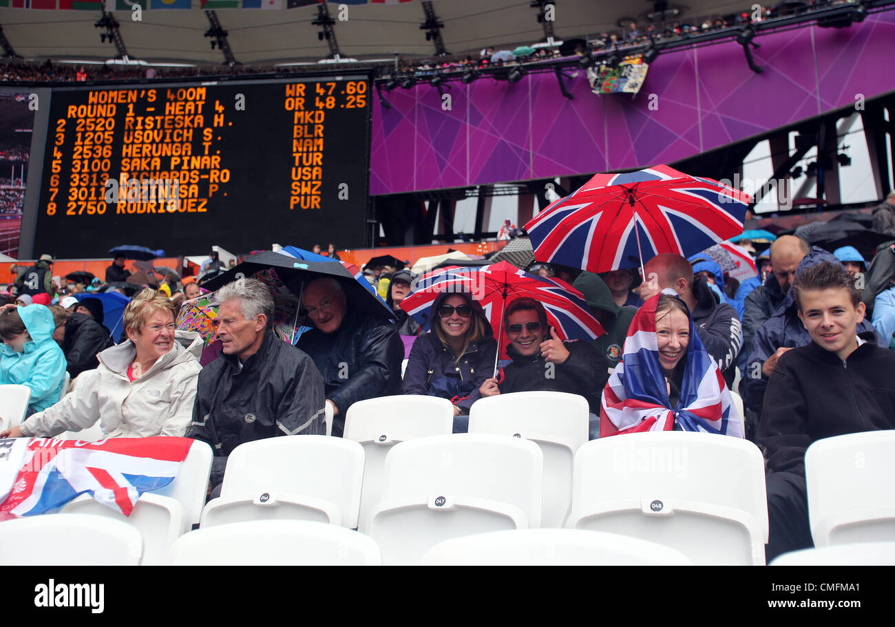 OLYMPIC FANS IN THE RAIN AT THE OLYMPIC STADIUM WATCHNG THE MENS 3000M ...