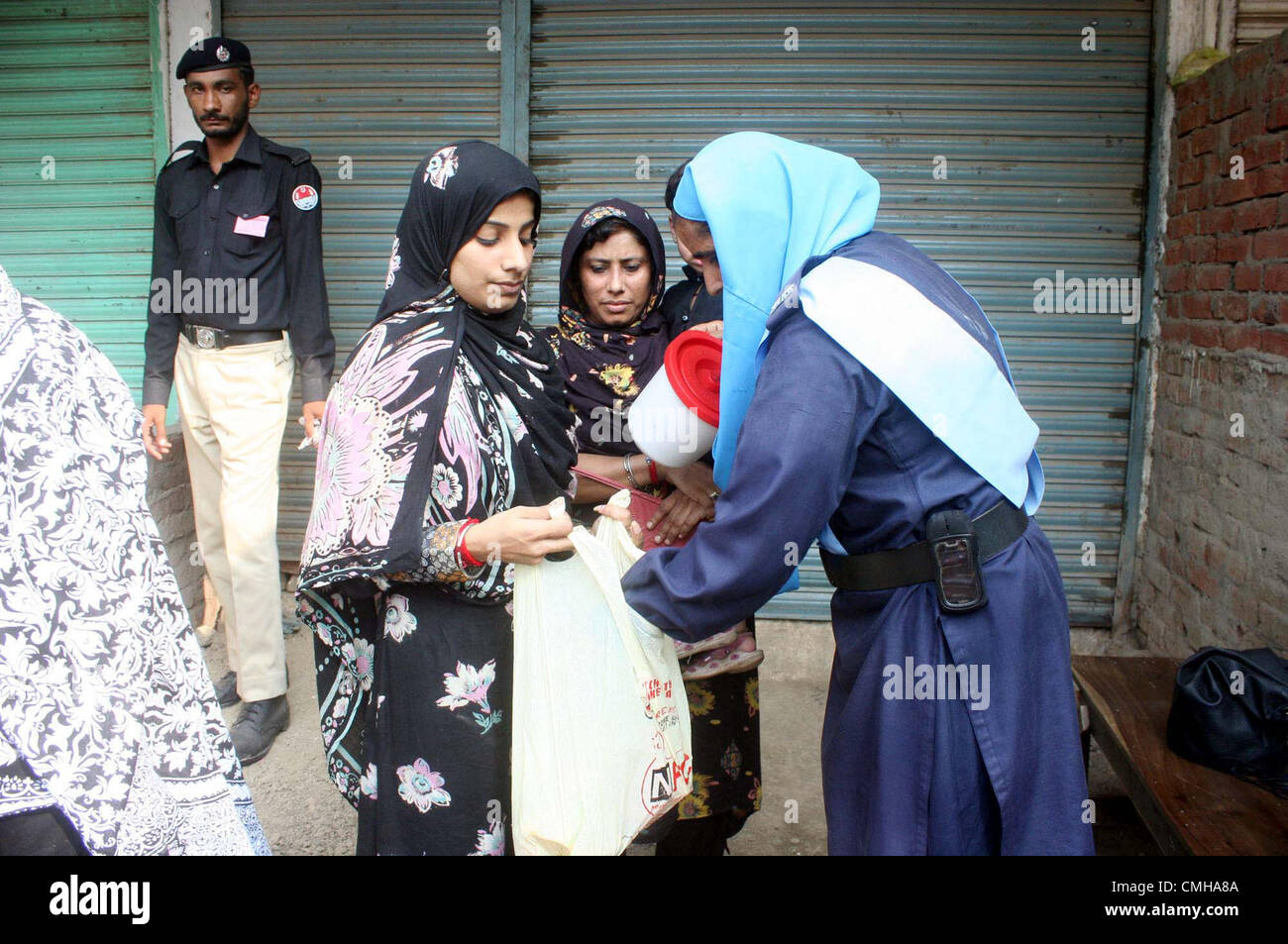 A woman police official checks handbags of women who are entering in ...