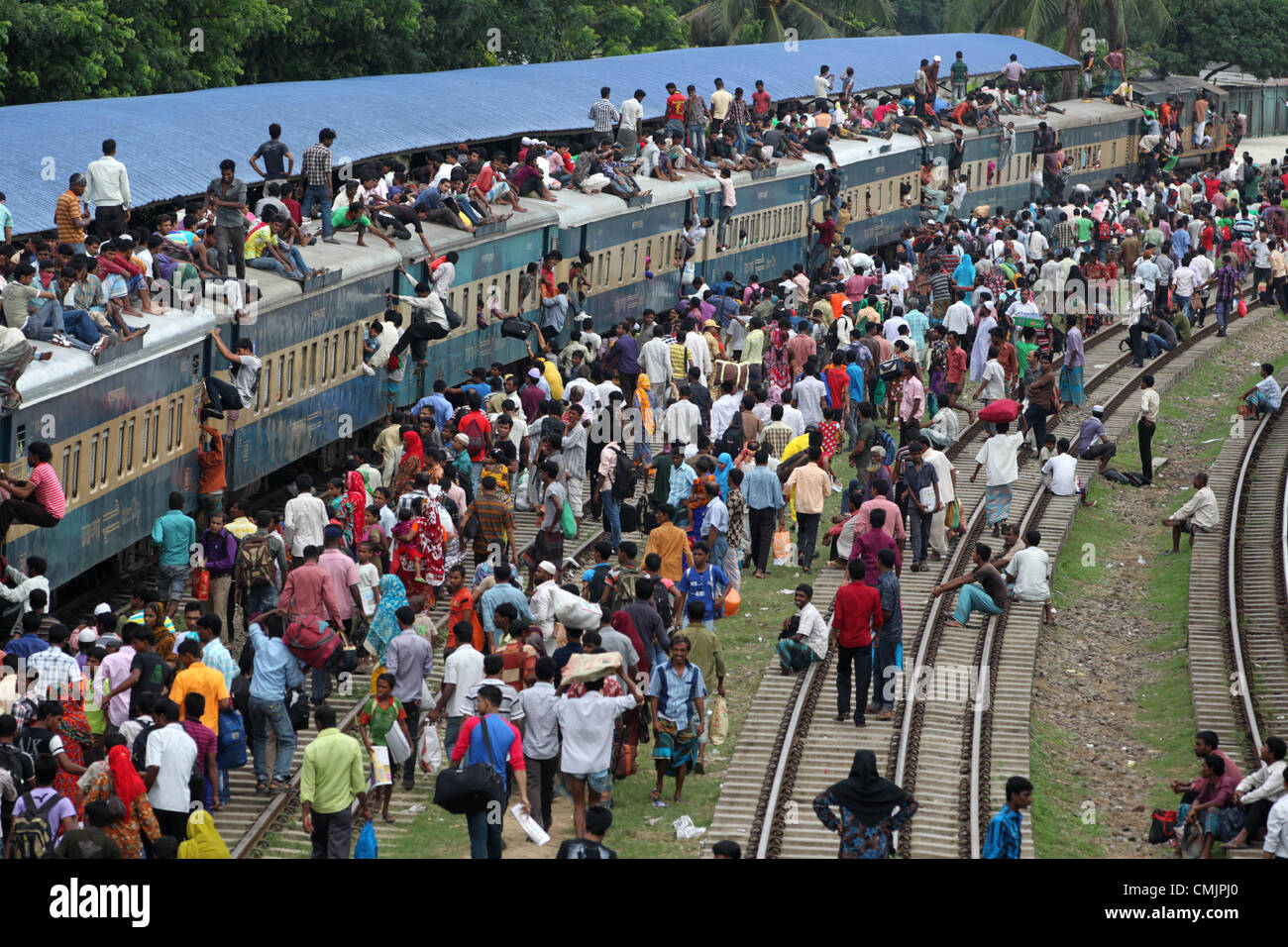 Dhaka, Bangladesh. August 18th, 2012. Homebound people climb on the ...