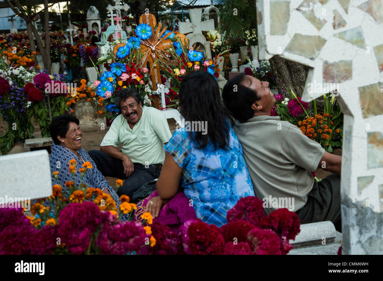A Mexican family shares a light moment at the gravesite of a loved one ...