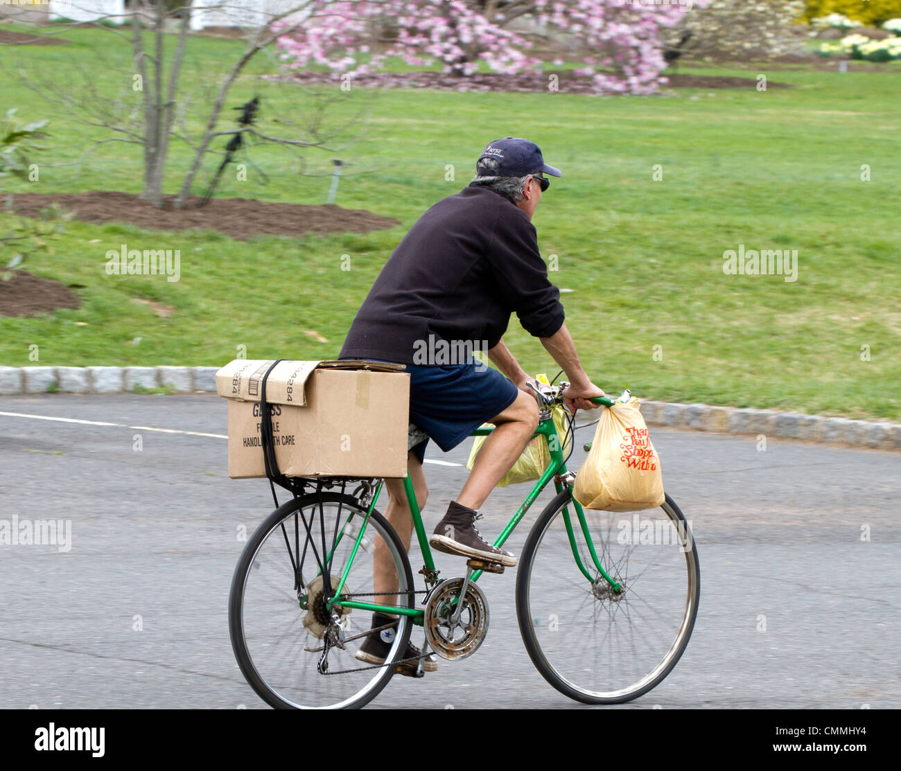 A homeless man on a bicycle with bags and box Stock Photo - Alamy