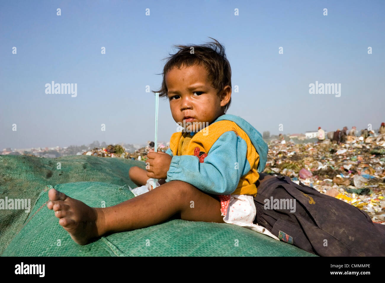 A young child laborer boy is enjoying a drink at the Stung Meanchey ...
