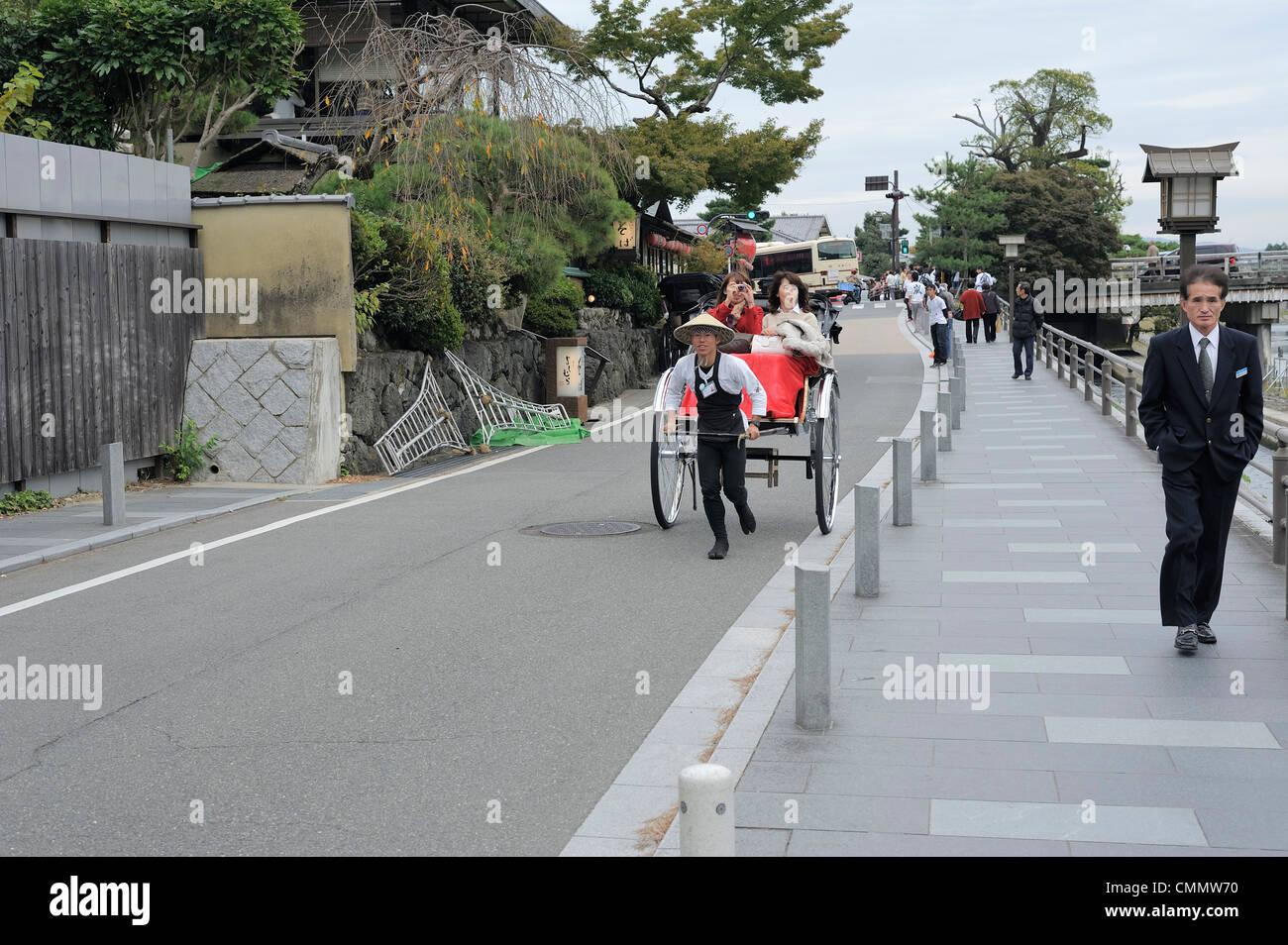 young Japanese man pulling rickshaw with two Japanese women in ...