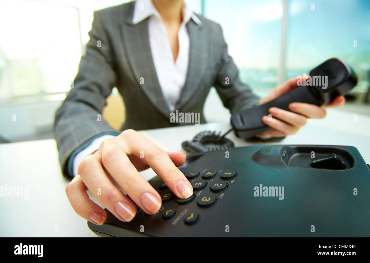 Female hand holding phone receiver and dialing number Stock Photo - Alamy
