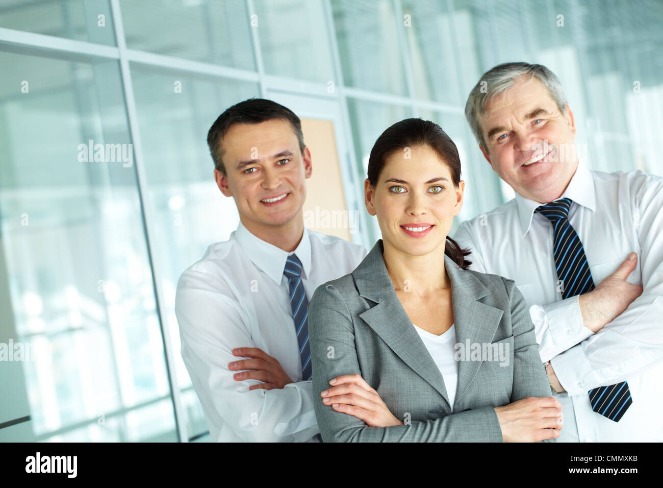 A business team with pretty leader in front looking at camera and ...