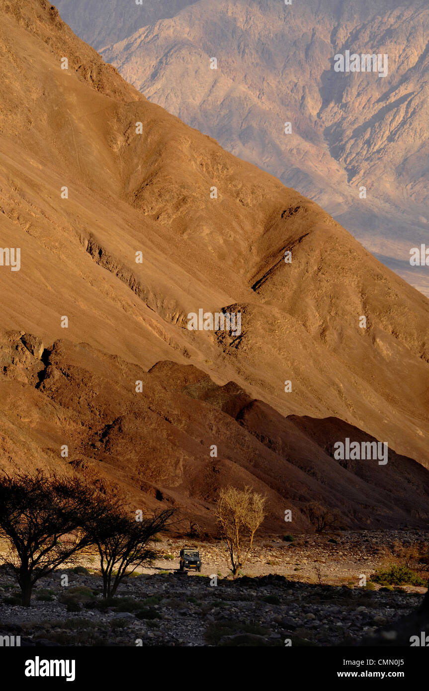 Jeep driving through a large desert valley in the Southern Negev desert ...