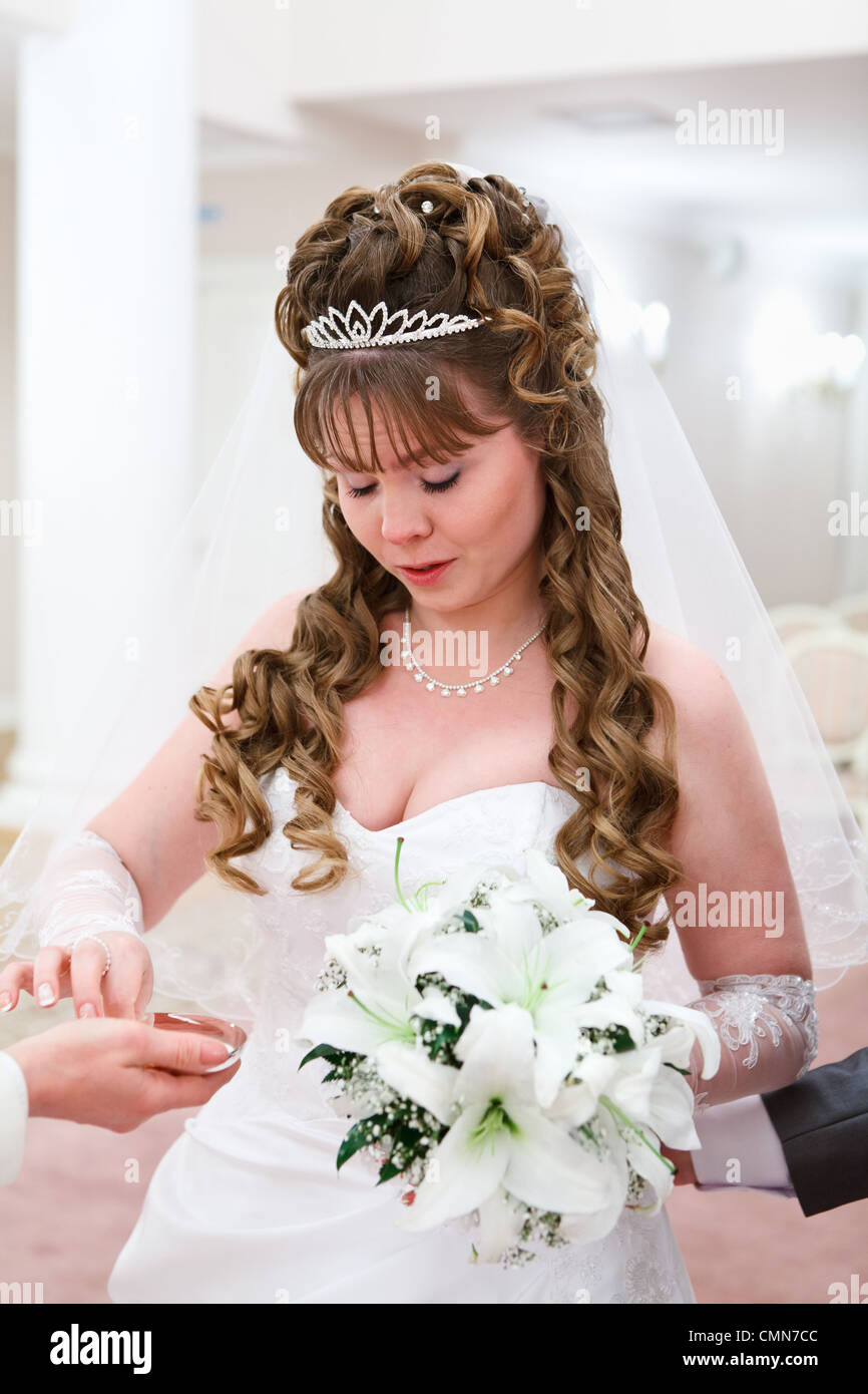 Russian bride takes a ring with tears on eyes during wedding ceremony ...