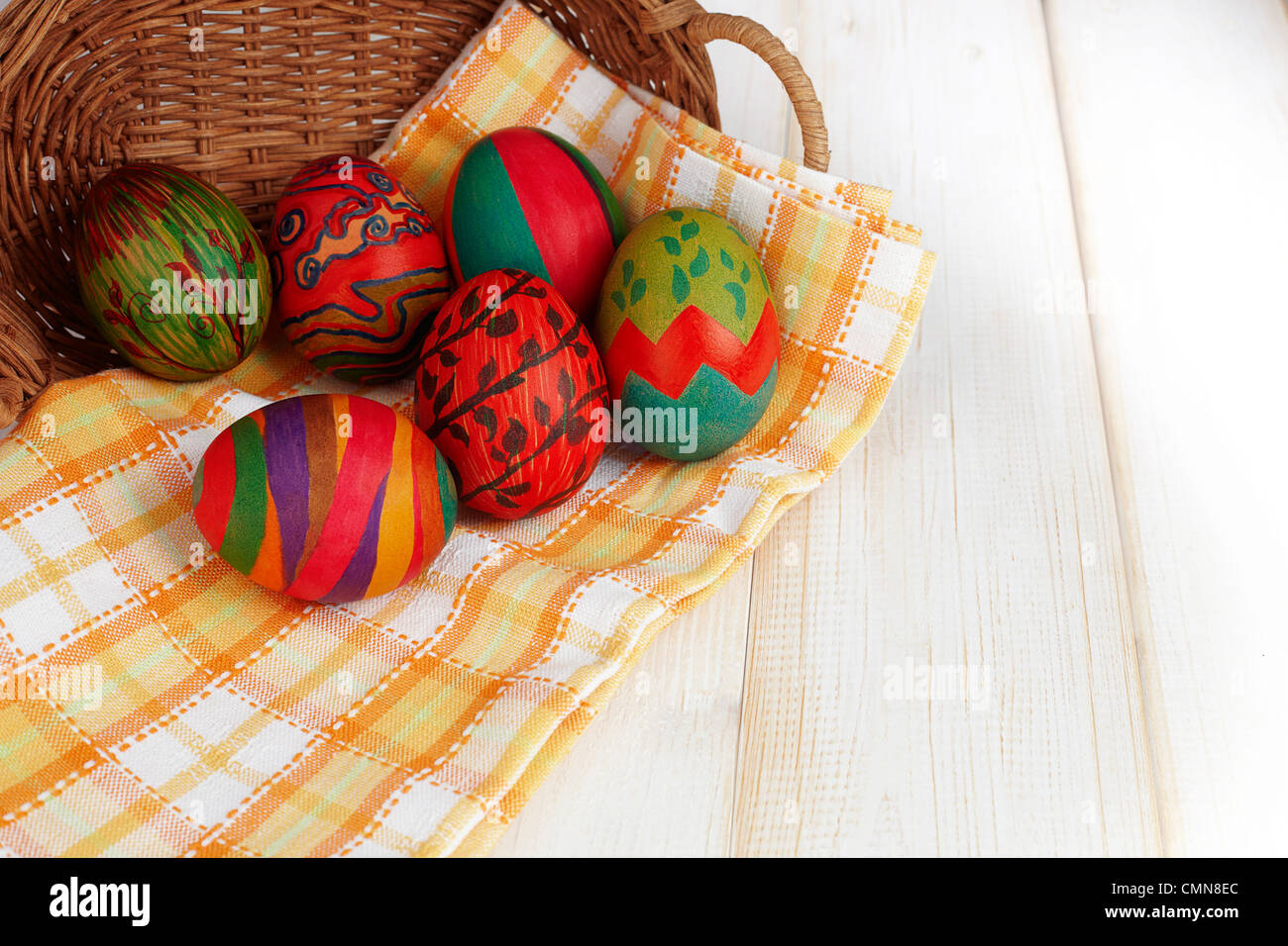 colorful Easter eggs on plaid napkins and rattan baskets Stock Photo ...