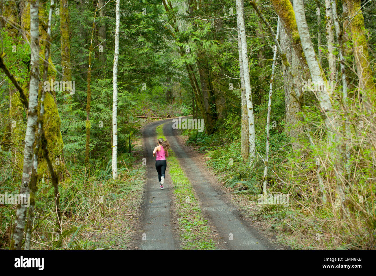 Mixed race runner training on remote road Stock Photo - Alamy