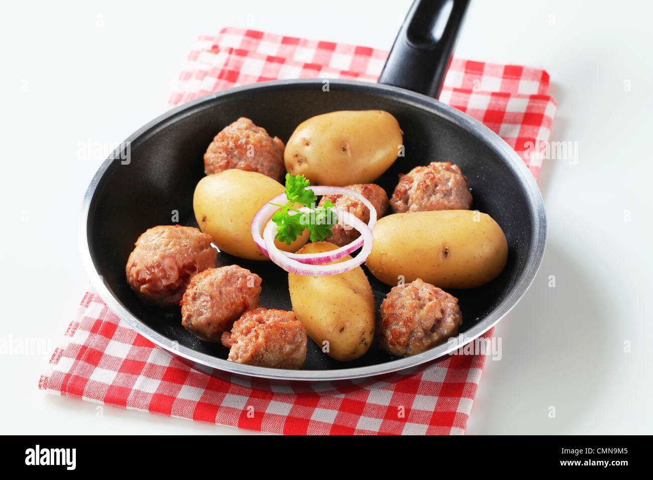 Pan-fried meatballs and potatoes in a fry pan Stock Photo - Alamy