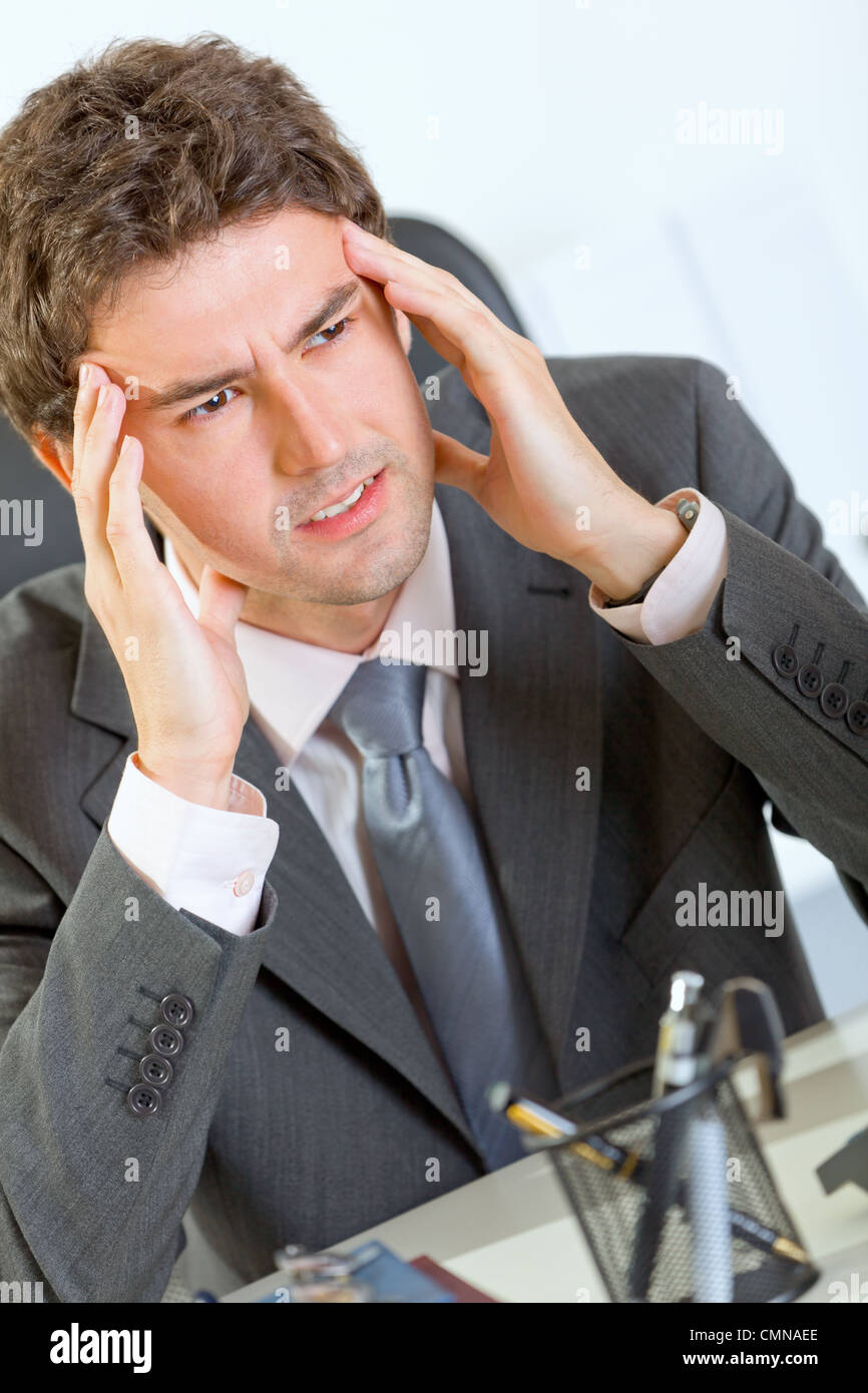 Portrait of stressed modern businessman sitting at office desk Stock ...
