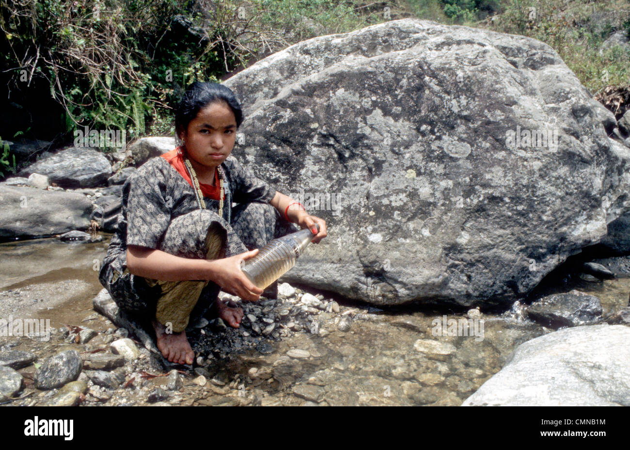 Nepalese girl taking water from a river in the Helambu-Langtang area ...
