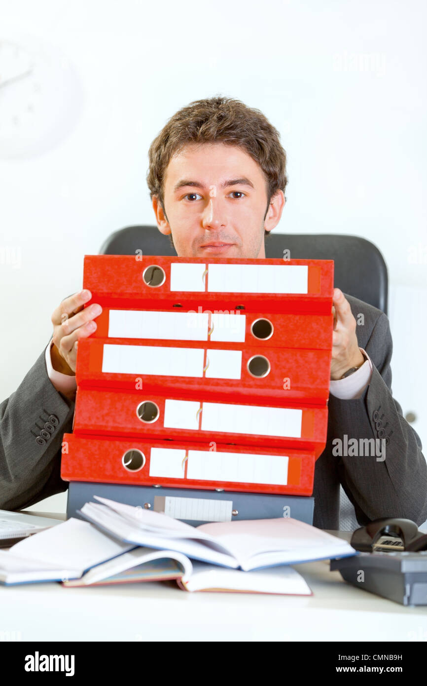 Sitting at office desk confused modern businessman looking out from ...